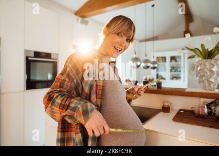 Happy woman with asparagus sticks standing in kitchen at home Stock ...
