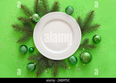 Composition with empty plate, fir branches, Christmas decorations and ...