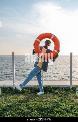 Full length portrait of a happy lifeguard on duty giving a thumb up ...