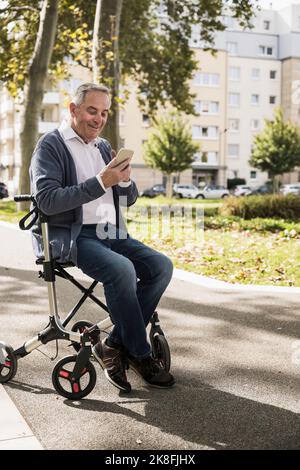 Senior Caucasian man using walker for support while young adult woman ...