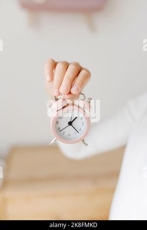 Female hand with alarm clock at home, closeup. Daylight saving time ...
