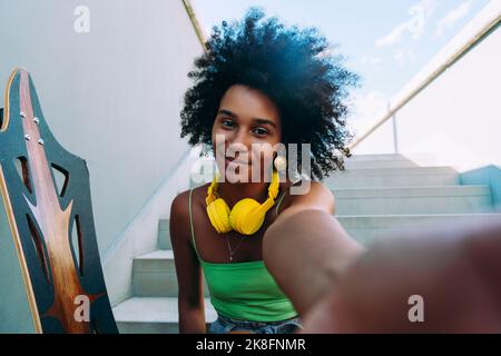 Young woman with headphones talking selfie on mobile phone Stock Photo ...