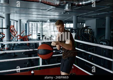 Young boxer trains with punching bag in gym Stock Photo - Alamy