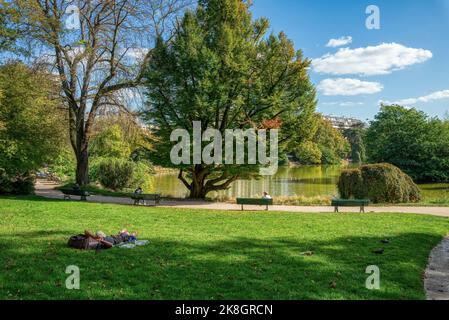 Parisians sunbathing on the shore of the lake of Parc Montsouris ...