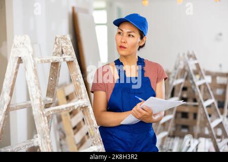 Woman builder checking project documentation Stock Photo - Alamy