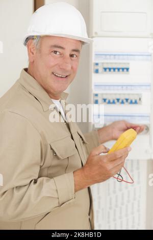 portrait of male electrician using multimeter to test socket Stock ...