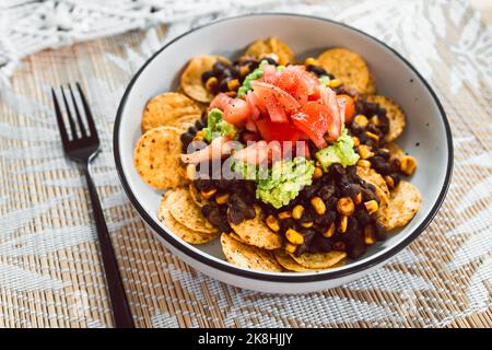 plant-based mexican bean nachos with corn chips guacamole and tomato ...