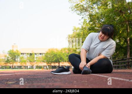 Asian overweight woman a new runner pain ankle during running, Athlete ...