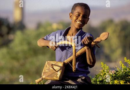 Ethiopia, Addis Abeba; Portrait of a boy playing traditional Ethiopian ...