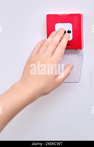 Woman reaches for the fire alarm, hand turns on the call button for ...