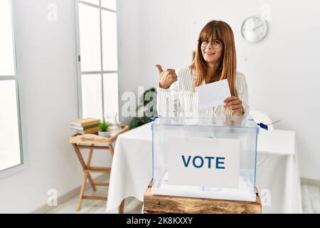 Hispanic business woman voting putting envelop in ballot box hand on ...