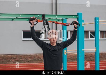 Professional athlete stretches and strengthens his arms, shoulders and ...