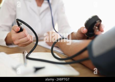 Doctors hand measuring blood pressure of male patient Stock Photo - Alamy