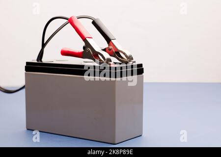 connected bolts charging battery positive pole and negative pole, white ...