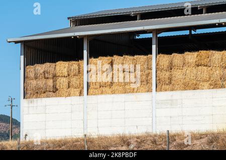 An aerial view of various hay straw bales stored behind wire fences ...