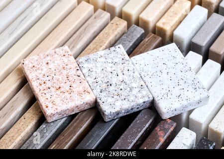 Porcelain three stoneware square samples laid on kitchen countertop ...