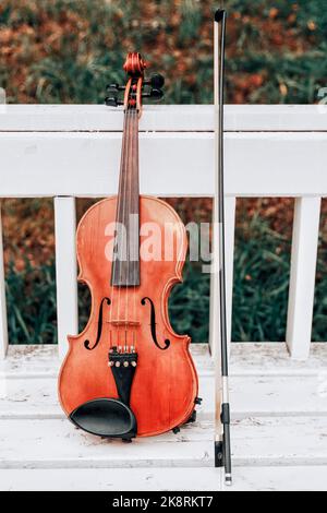 violin with a bow lies on a white bench. High quality photo Stock Photo ...