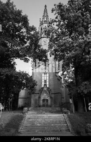 A vertical grayscale of a church with trees in the foreground Stock ...