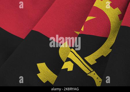 Angola flag with big folds waving close up under the studio light ...