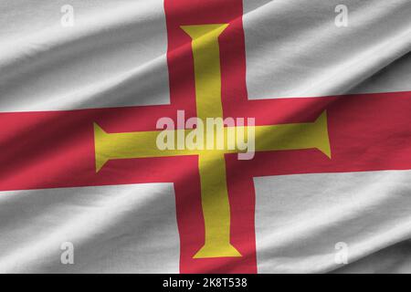 Guernsey flag with big folds waving close up under the studio light ...