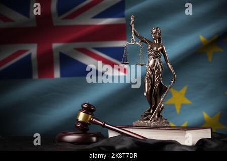 Tuvalu flag with statue of lady justice and judicial scales in dark ...