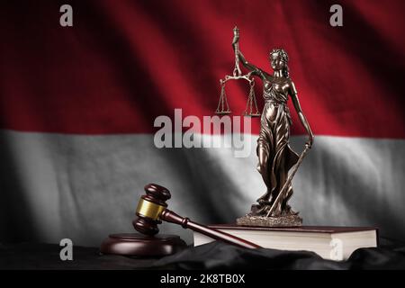 Monaco flag with statue of lady justice and judicial scales in dark ...