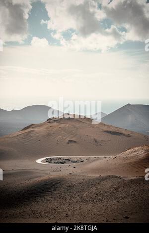 Vertical shot of a sandy road and a beautiful sunrise in the background ...