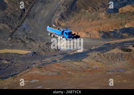 Large trucks transport excavated earth and rocks for highway ...