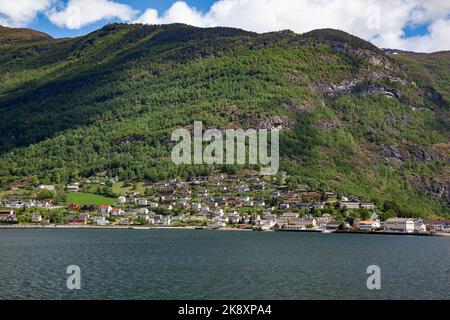 A Narrow Fjord surrounded by mountains covered with historical village ...