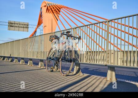 A bicycle leaning on the sidewalk fence of the Southern Bridge in Riga ...