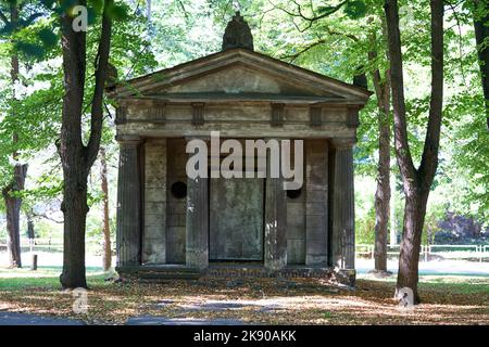 An old weathered crypt between trees in the Great cemetery in Riga ...