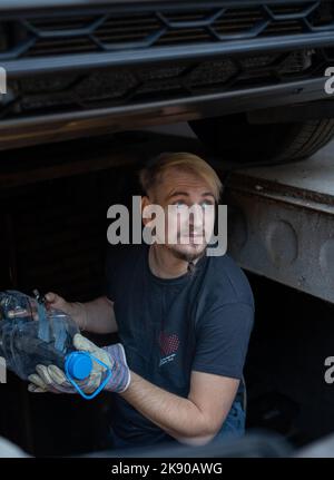 The mechanic services the car under the car Stock Photo - Alamy