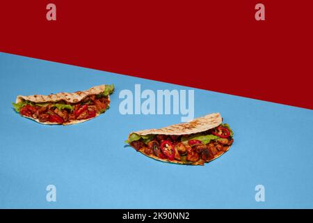 Mexican cuisine. Appetizing and juicy tacos on red-blue background ...