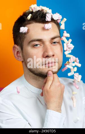 Marshmallows sprinkle on the mans head. Bright man portrait with sweets ...