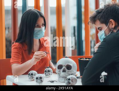 The people in masks talking about skull and bat halloween toy ...