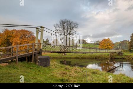 Autumn colours surround the Hebden Suspension Bridge spanning the River ...