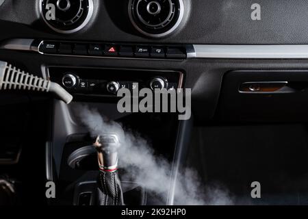Steam cleaning of gearbox and dashboard in car. Vaping steam. Cleaning ...