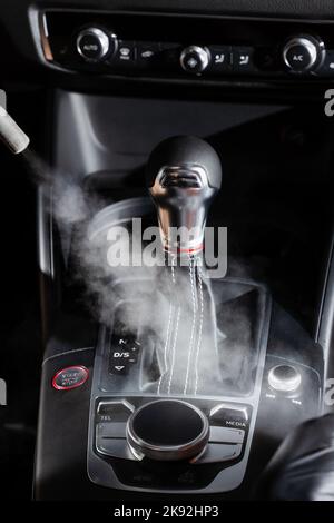 Steam cleaning of gearbox and dashboard in car. Vaping steam. Cleaning ...