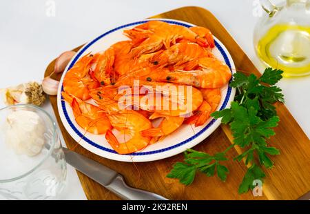 Chilled red whole prawns on plate with garlic, parsley and olive oil ...