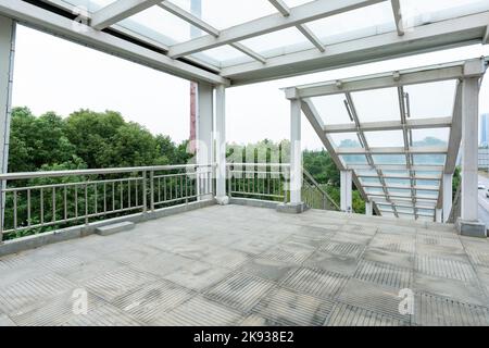 Inside of a modern overhead pedestrian bridge over a highway on a sunny ...