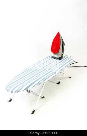 new clothes iron on white background, red ceramic iron, and blue fabric ...