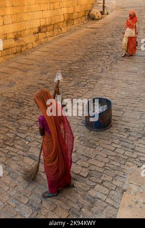 A vertical shot of a woman using a manual wall mounted hand sanitizer ...