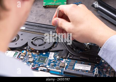 Hands fixing motherboard of pc or laptop notebook close up in service ...
