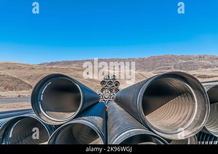 Flexible conduit or culvert pipes stacked up in an active landfill or ...
