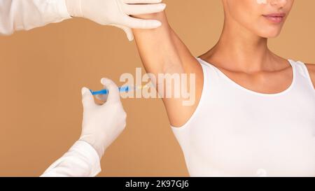 Woman receiving underarm hyperhidrosis treatment. Armpit injections to ...