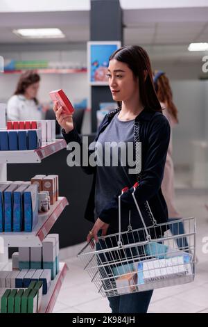 Asian customer looking at cardiology pills boxes to buy medicine ...