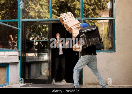 Deliveryman dropping pizza boxes huge pile back view, clumsy courier ...