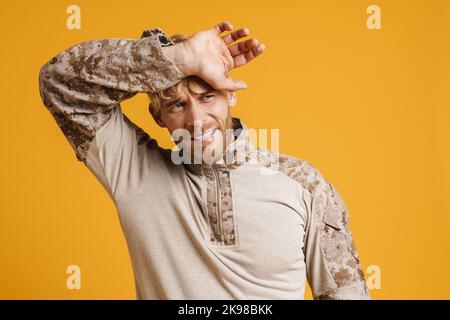 European military man with headache holding his head isolated over ...