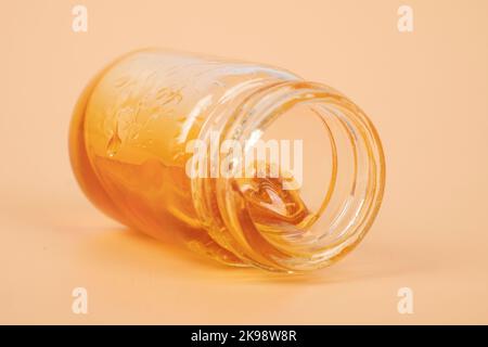 glass jar with brown cannabis wax, pieces of hardened resin of ...