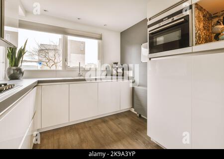 Comfortable sofa with cushions and pouf located near doors and dining ...